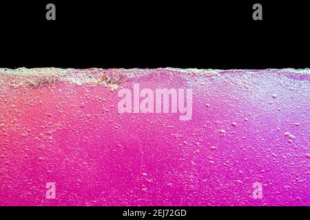 Pink bubbly boiling water against black background Stock Photo - Alamy