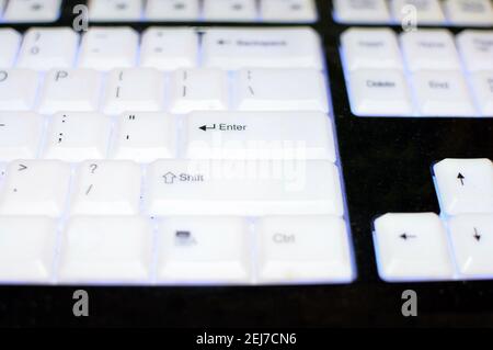 Top side view of an illuminated keyboard with black letters on white ...