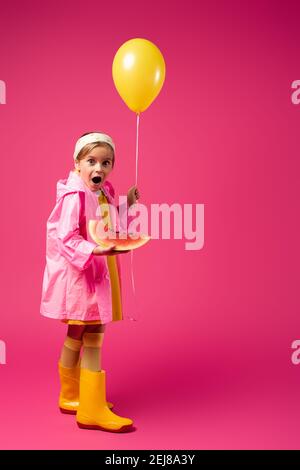 happy amazed child hold fresh apple and pear on yellow background Stock ...