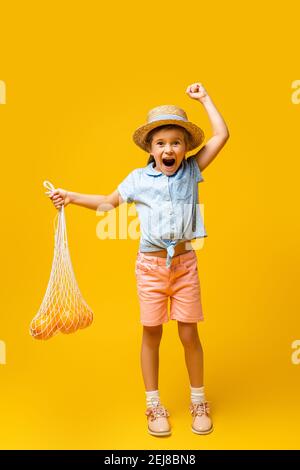 happy amazed child hold fresh apple and pear on yellow background Stock ...