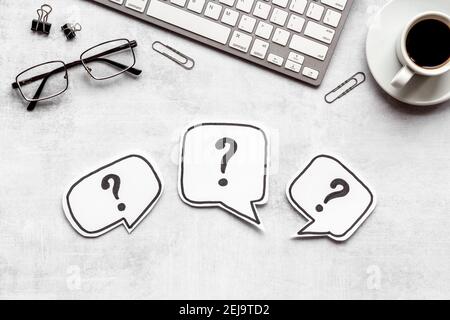 Question marks on office dest - FAQ concept. Top view Stock Photo - Alamy