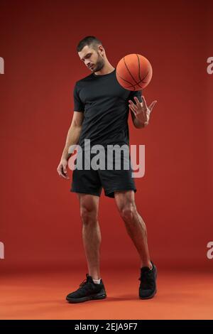 Young bearded man, competitive basketball athlete practicing, training ...