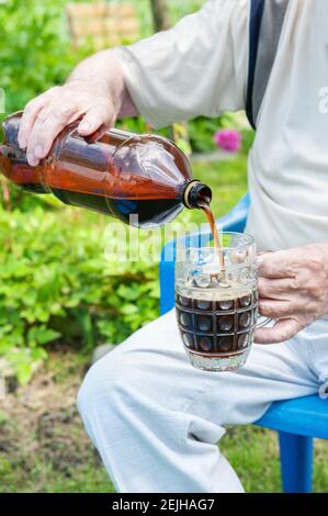 A person pours a yellow liquid from a teapot through a woven strainer ...