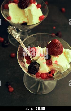 Strawberry ice cream with different berries and mint on a gray ...