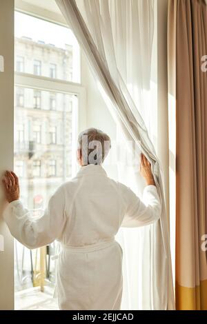 A person looks out a hotel window as police respond to a shooting in ...