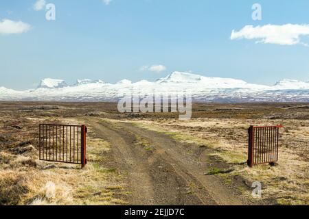 Gate in the middle of nowhere leading to snowy mountains, Iceland ...