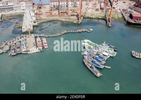 An aerial view of fishing ships either parking at or floating around a ...