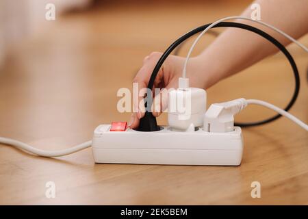 Woman pluging the wire into white extension cord. Close up of female ...