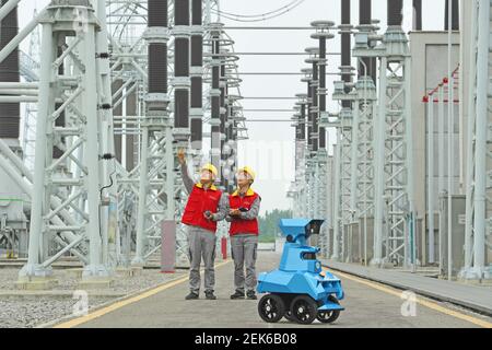 Assisted by robots, staff patrol along equipment to ensure summer ...