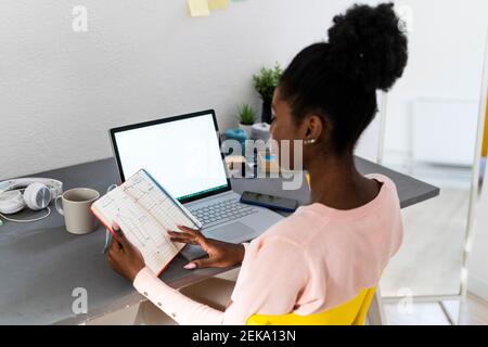 African american fashion designer analyzing document while working in ...