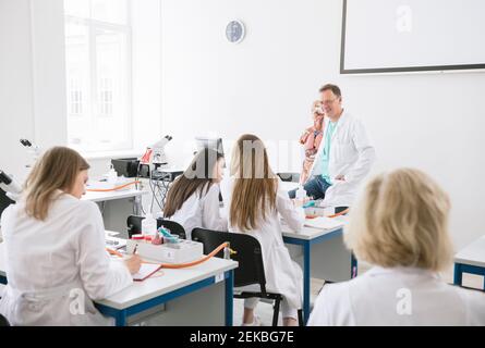 Professor is in the classroom and having a lecture to his students ...