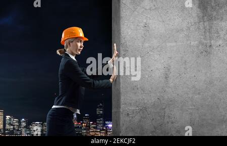Beautiful woman architect pushing concrete wall Stock Photo - Alamy