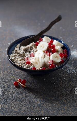 vertical image of a bowl with oatmeal and banana accompanied by a glass ...