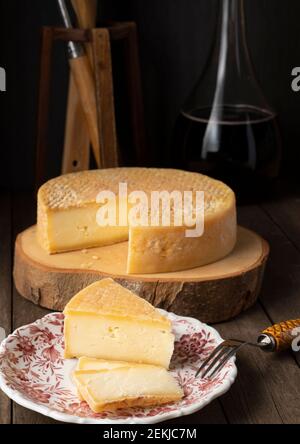 Moody brazilian Canastra artisanal cheese and almonds over a wooden ...