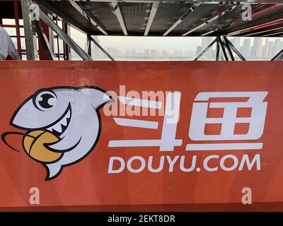 DouYu live streaming service logo on the smartphone screen behind the ...