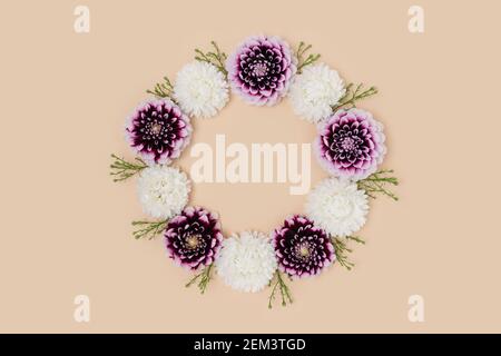 Wreath made of dahlia on a beige background. Flower round frame with ...