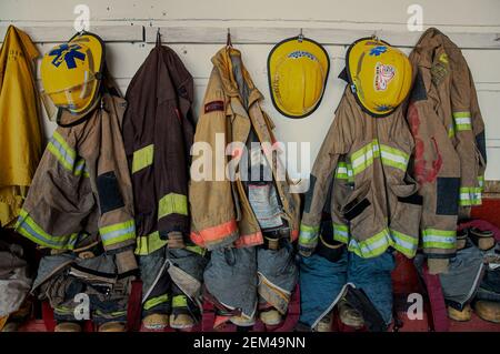 firefighters turnout gear hanging on racks Stock Photo - Alamy