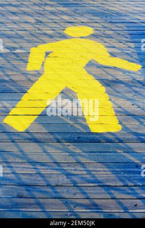 A pedestrian crossing sign is painted on the brick pavement, a common ...