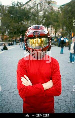 Close-up of man wearing crash helmet while standing on mountain against ...
