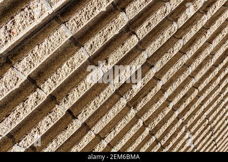 A grooved concrete exterior wall shot at an angle makes diagonal lines ...
