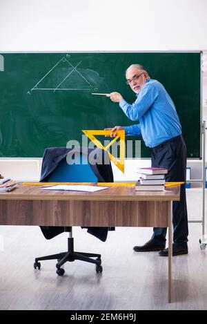 Senior male geometry teacher holding triangle Stock Photo - Alamy