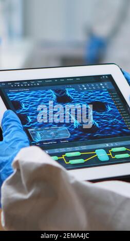 Team of scientists in coverall researching virus mutations working in ...