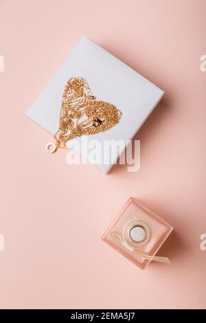 A gift for Valentine's Day. Perfume and a box with a gold chain on a ...
