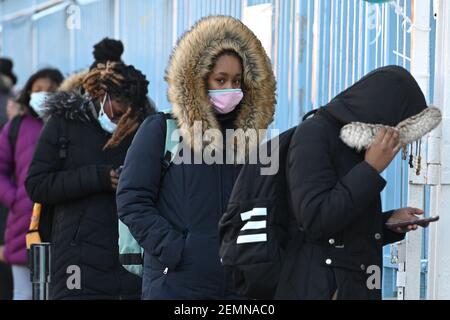 Returning students wear masks as they wait in line to resume in-person ...