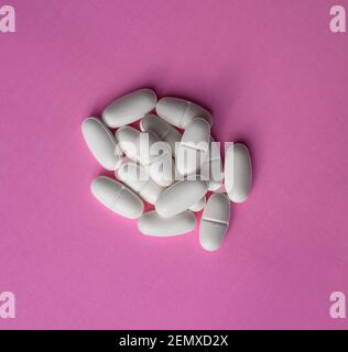 Calcium pink pills close up on blue background. Medicine concept. Food ...