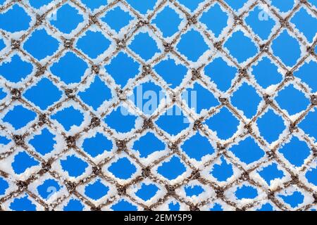 Net covered with snow against blue sky on clear winter day. Nature's ...