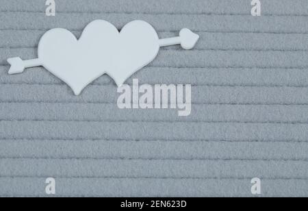 Crossing hearts embedded on a grey tissue Stock Photo - Alamy