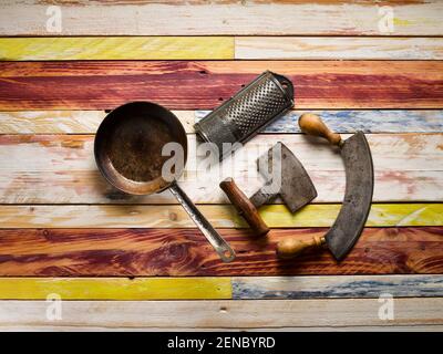 selection of old or antique cooking utensils hanging on a rack in a ...