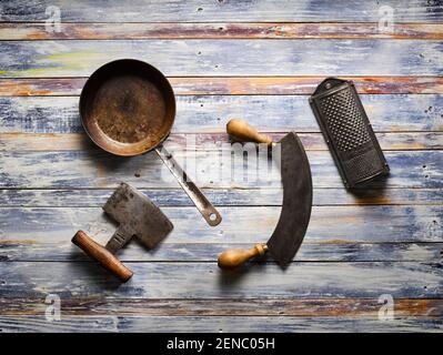 selection of old or antique cooking utensils hanging on a rack in a ...