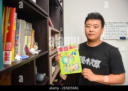 Chinese cartoonist Cheng Peng poses for photos at home in Qingdao city ...