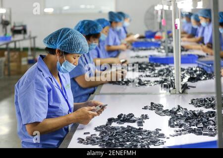 Chinese female workers manufacture makeup brushes on an assembly line ...