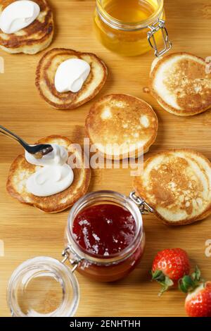 Blini served with strawberry jam, honey, sour cream and fresh berries ...