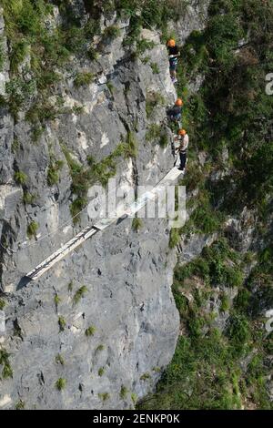 Tourists climb the Cloud Bridge, part of the Via Ferrata project, at ...