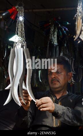 Pakistani Shiite Muslim select knives attached to chains that are used ...