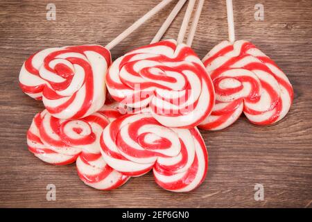 Sweet colorful funny lollipop in shape of heart on blue boards ...