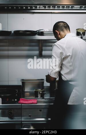 Portrait of a male chef backwards cooking in a restaurant kitchen Stock ...