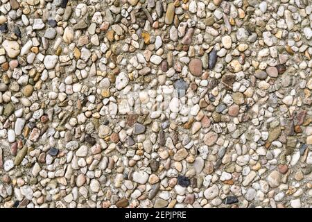 Colorful exposed aggregate concrete with gray, brown and blues pebbles ...