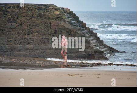 Swimmer approaching the sea at Brown’s Bay, Cullercoats, Tyne and Wear ...