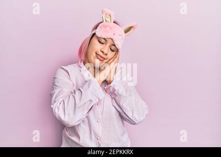 Leaning woman wearing pink robe holding open laptop in home kitchen ...