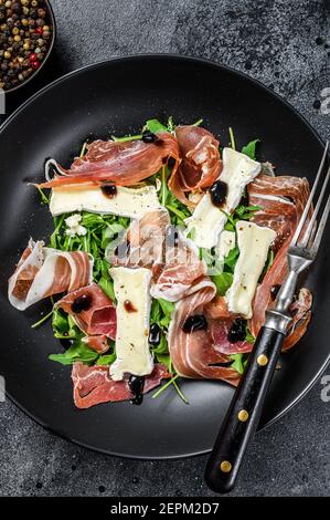 Prosciutto crudo ham salad with brie camembert cheese and arugula on a ...