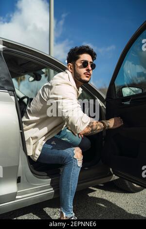 A male getting out of a modern car Stock Photo - Alamy