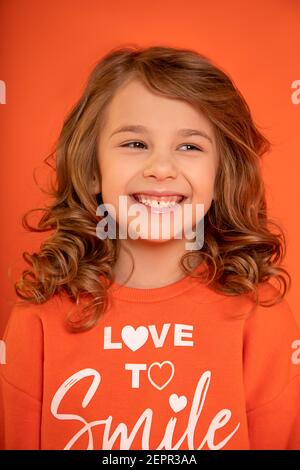 Photo of adorable cheerful girl toothy smile arm hold paper heart card ...