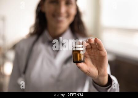 Female doctor with bottle of vitamin supplements and clipboard on blue ...