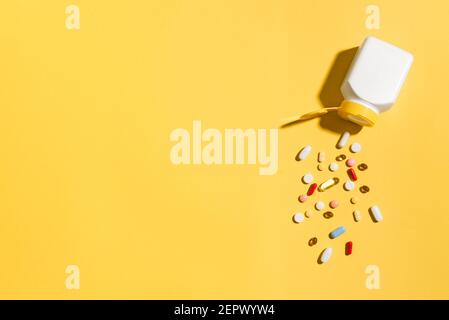Multicolored pills and capsules in plastic bottle on Colored background ...