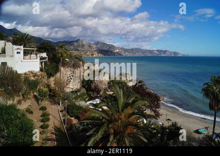 Scenic shot of the coastline at Nerja with palm trees , mountains ...