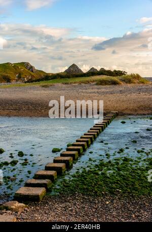 STEPPING STONES OVER PENNARD PILL WITH PENNARD CASTLE IN THE BACKGROUND ...